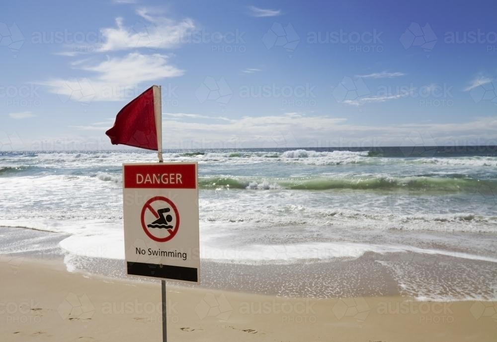 Image of Danger warning sign at rough surf beach - Austockphoto