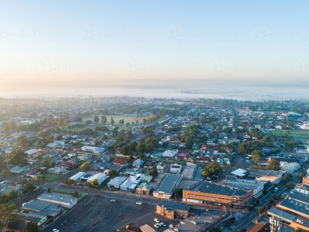 Image of Dawn light on buildings and shops in country town with fog ...