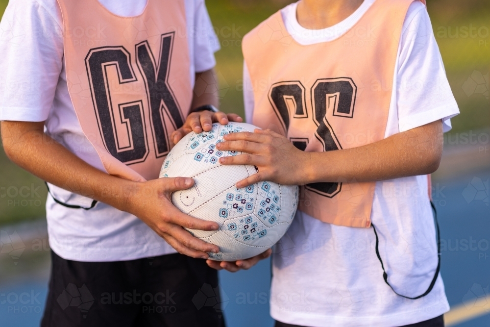 Image of detail of two children holding netball - Austockphoto