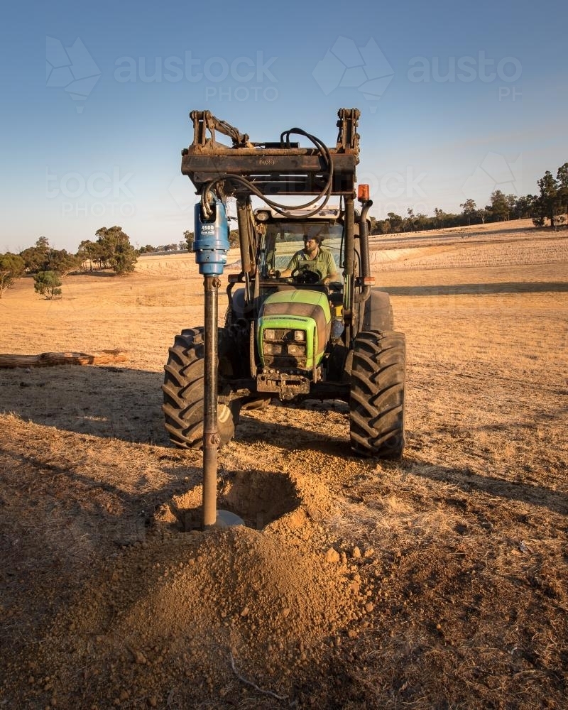 Image of Digging a hole with hydraulic posthole digger on tractor ...