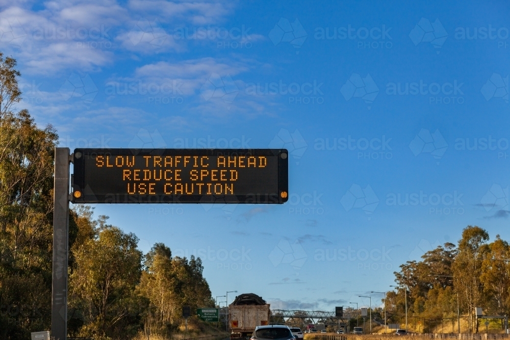 Image of Digital sign over road warning of slow traffic ahead reduce ...