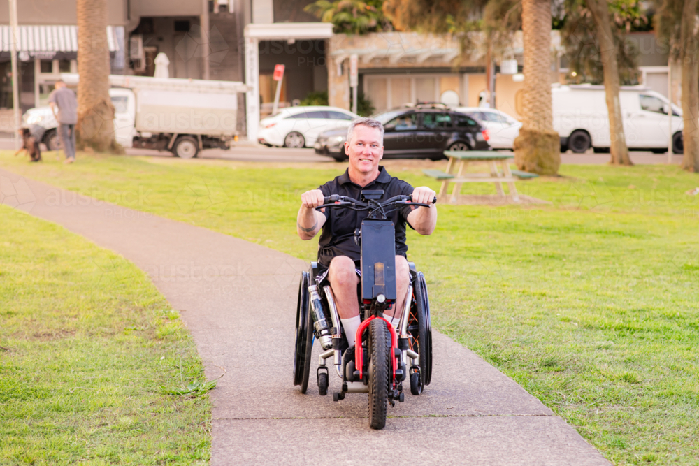 Image of disabled man in a motorised wheelchair - Austockphoto