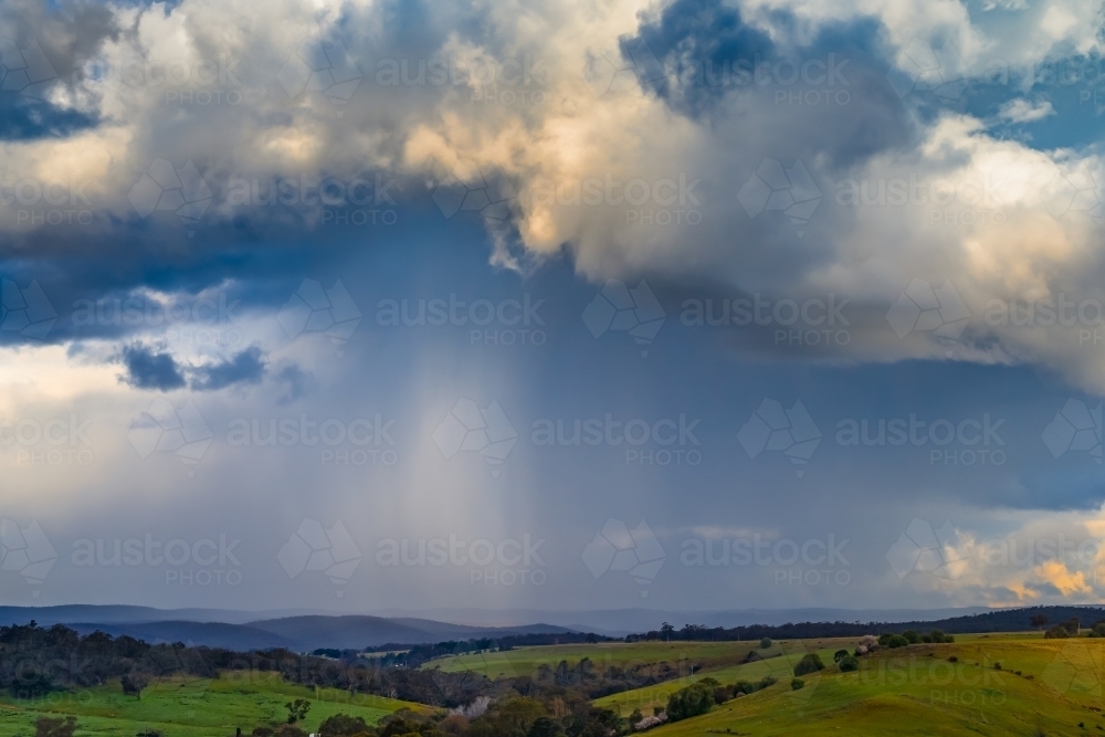 Image of Distant view of heavy rain falling from a dramatic cloud over ...