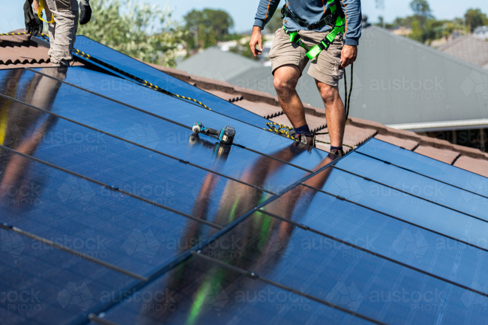 Image of Drill laying on all Black bifacial solar panels on roof during ...