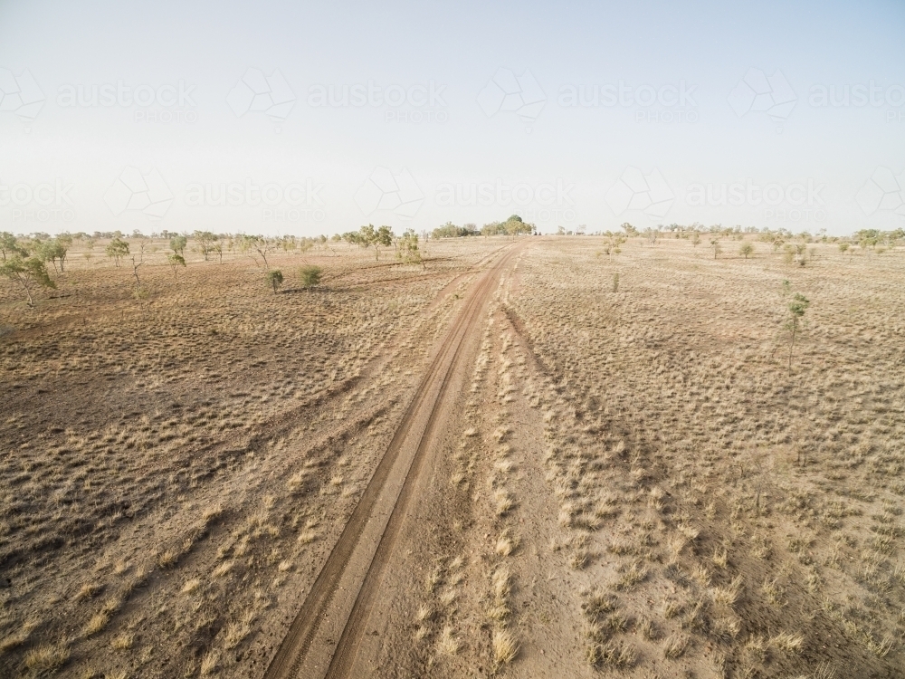 Image of Drone shot of dirt road through a paddock - Austockphoto