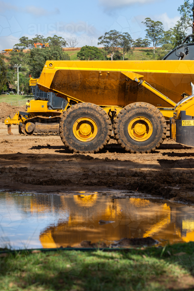 Image of Dump truck earthmoving machinery on worksite reflected in ...