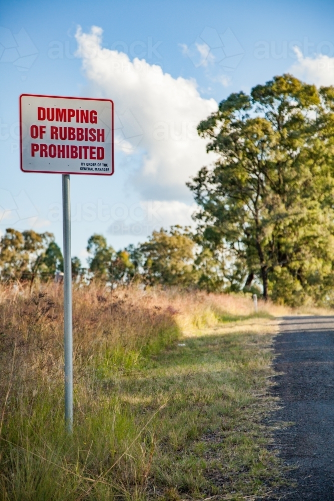 Image of Dumping of rubbish prohibited sign by the roadside - Austockphoto