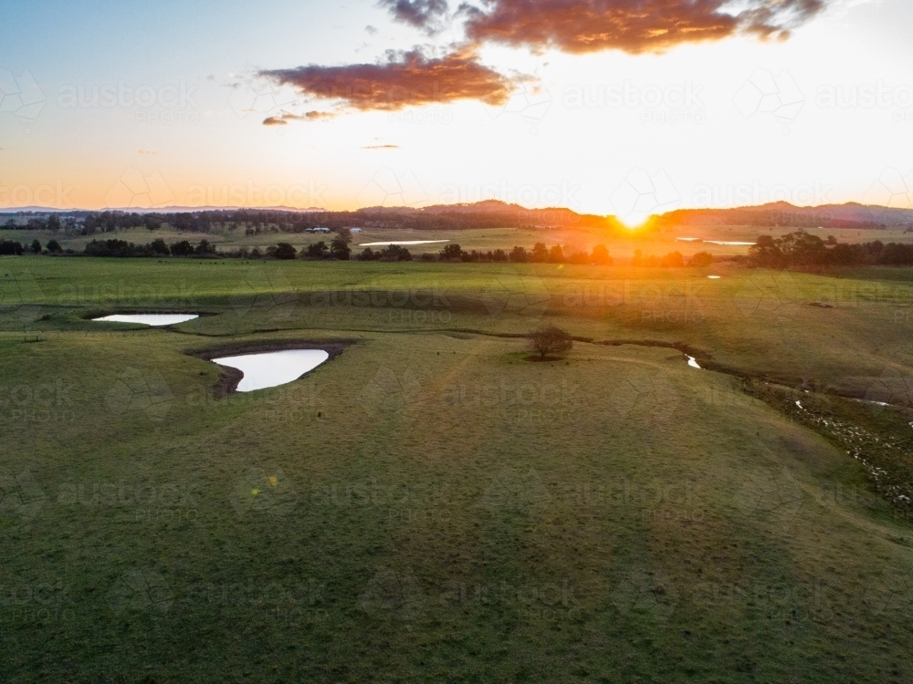 Image of Dusk light with sunset colours in clouds over dams in farm ...