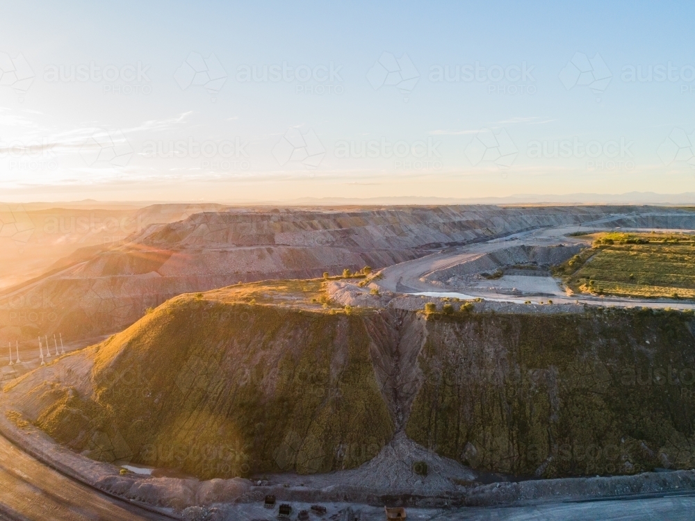 Image of Dust and evening light haze over slag heap hills in open cut ...