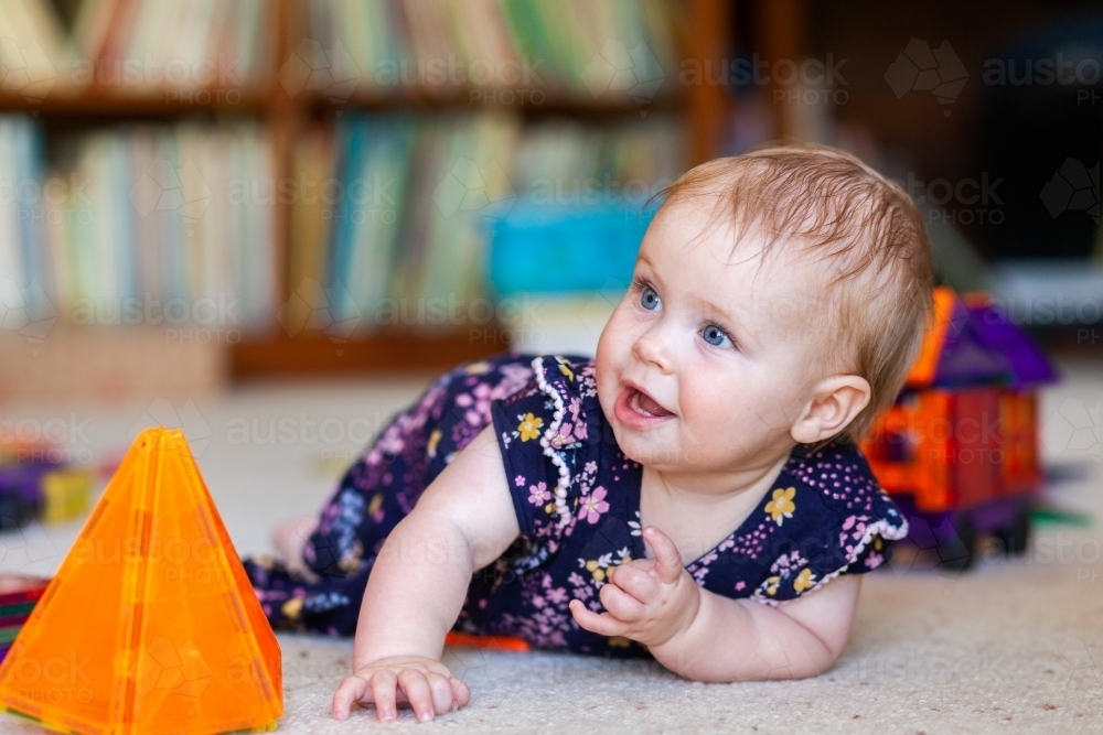 Image of Eight month old baby girl crawling among magnetic toy blocks ...