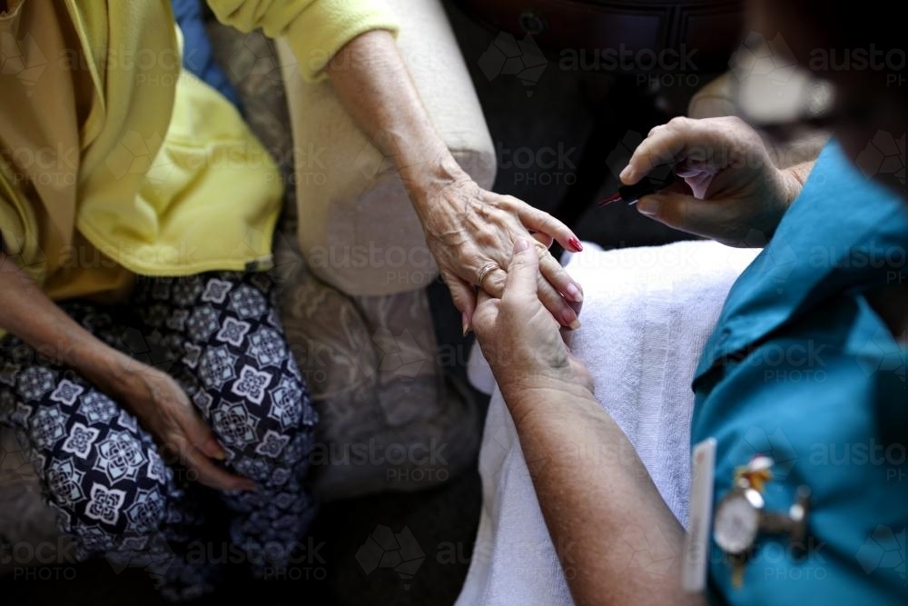 Image of Elderly lady having nails painted by carer at nursing home ...
