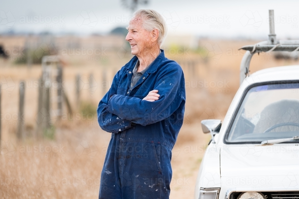 Image of Elderly man looking across the farm land. - Austockphoto