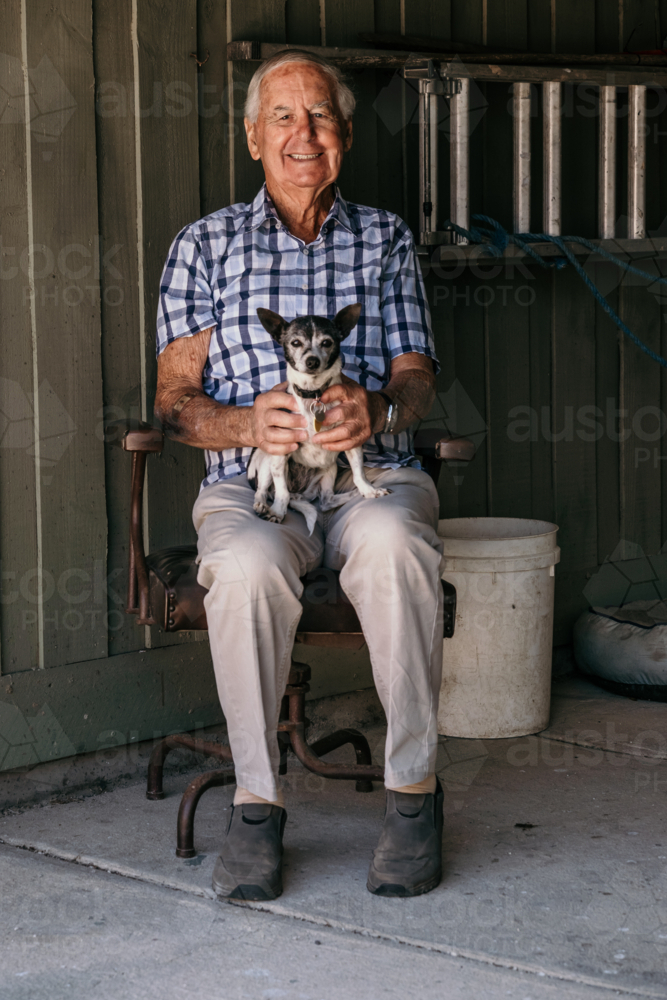Image of Elderly man sitting with his little dog. - Austockphoto