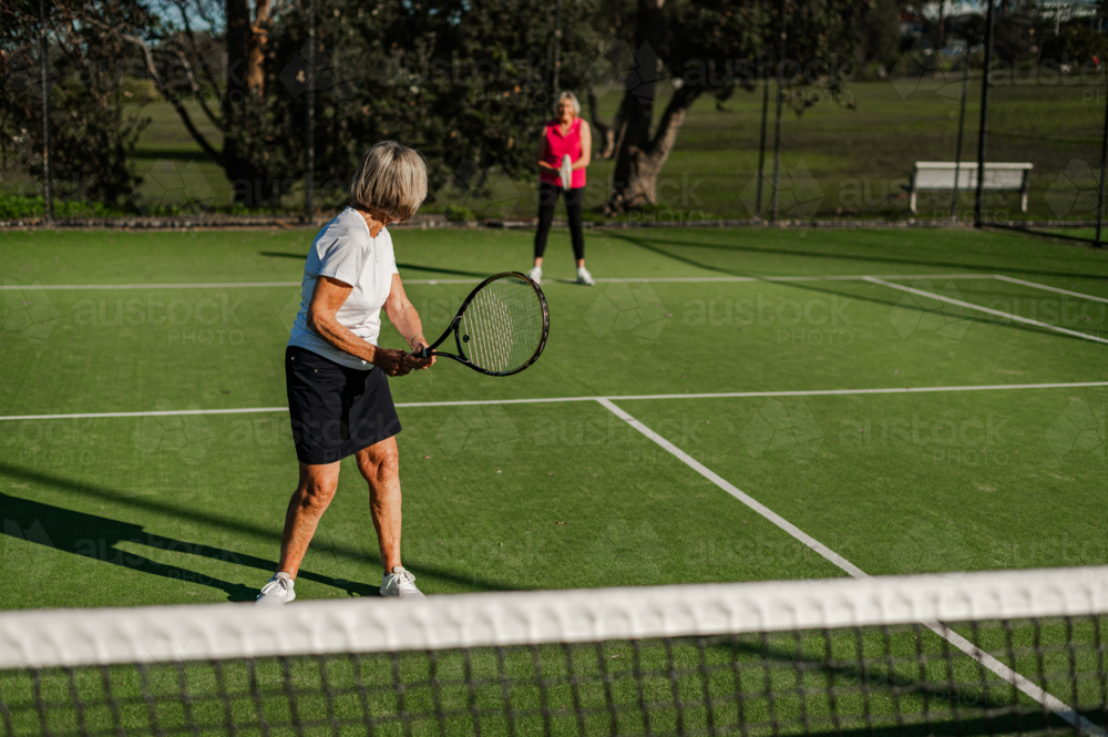 Image of Elderly woman prepares to hit a tennis ball - Austockphoto