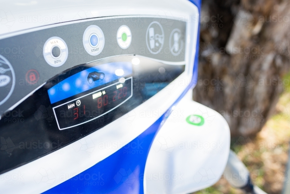 Image of Electric vehicle charging station with car plugged in filling ...