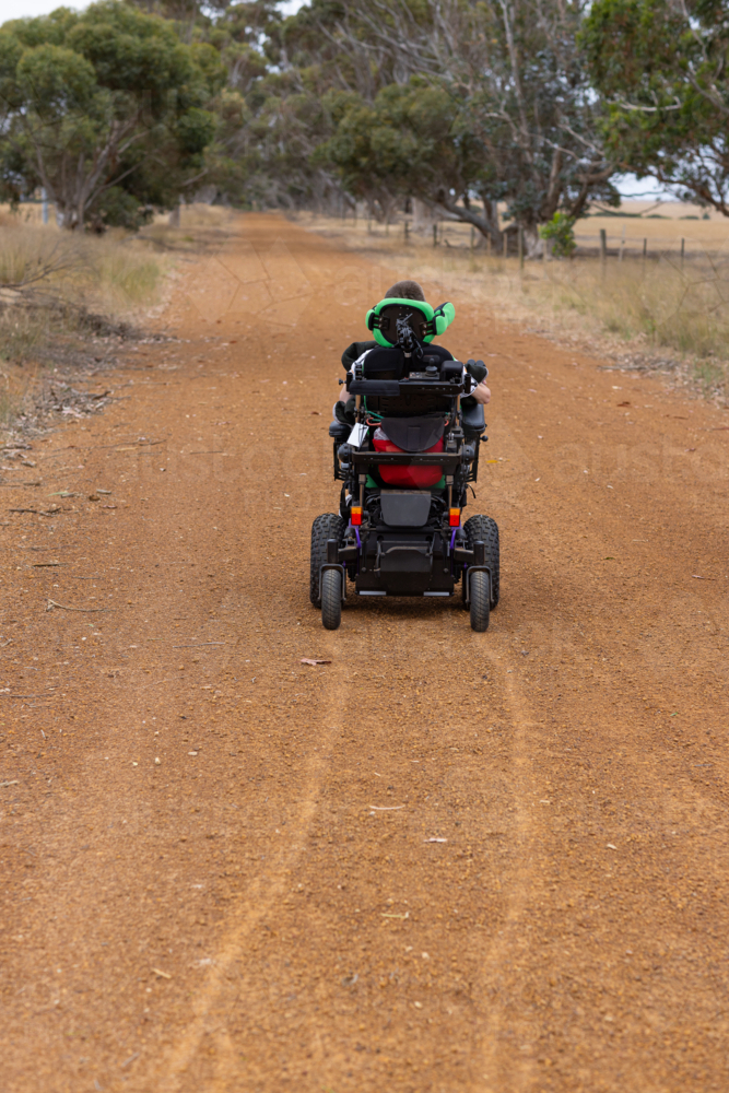 Image of Electric wheelchair operated by person with disability heading ...