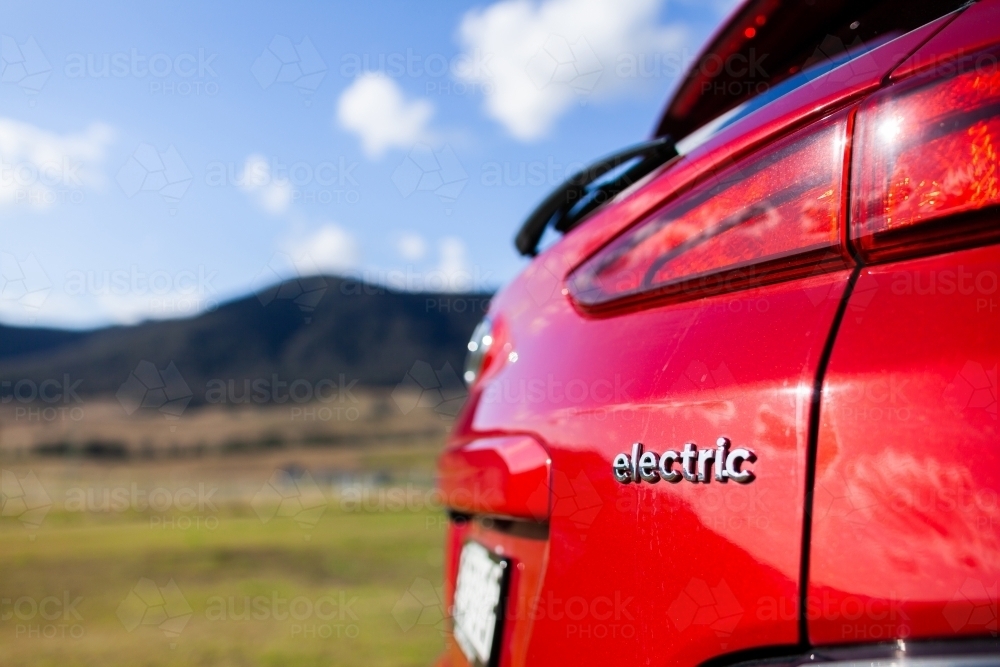 Image of Electric word in back of red electric vehicle car in rural ...
