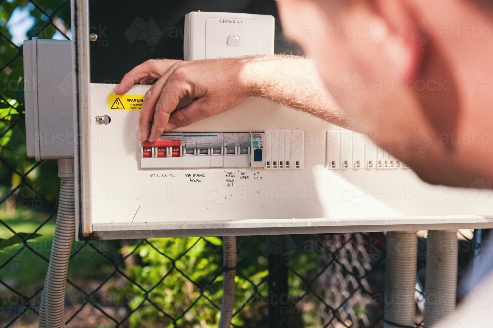 Image of Electrician checking switches at the power box - Austockphoto