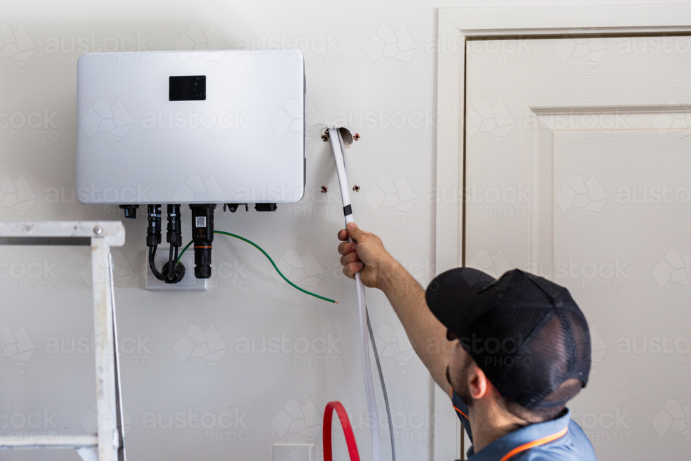 Image of Electrician running wires and cables through wall for solar ...