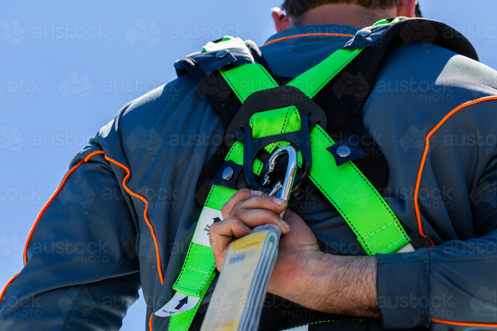 Image of Electrician tradie man clipping rope to safety harness during ...