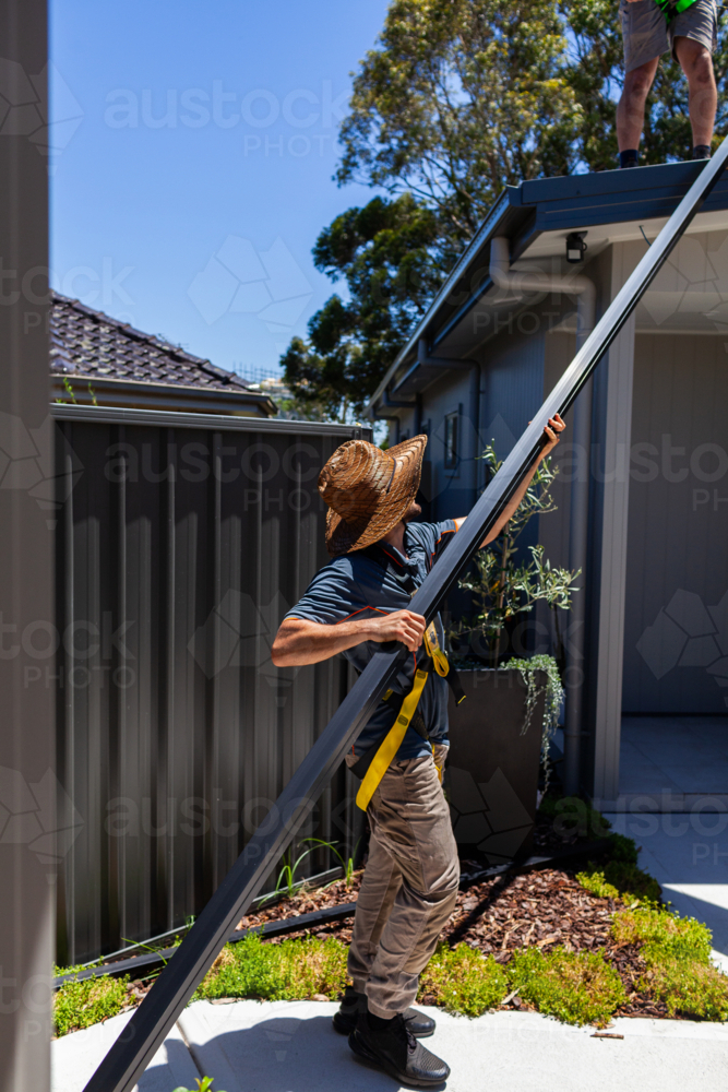 Image of Electrician tradie men working together to lift railing to ...