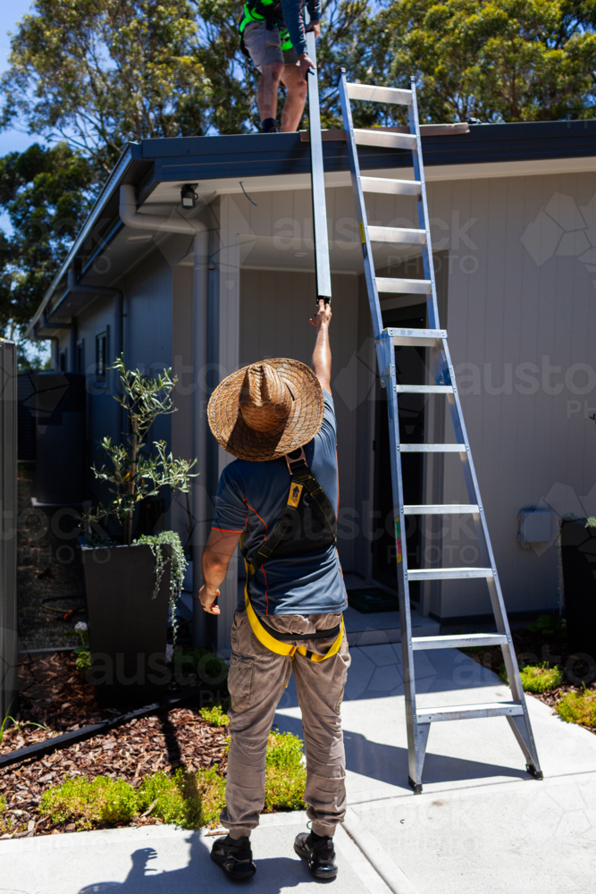 Image of Electrician tradie men working together to lift railing to ...