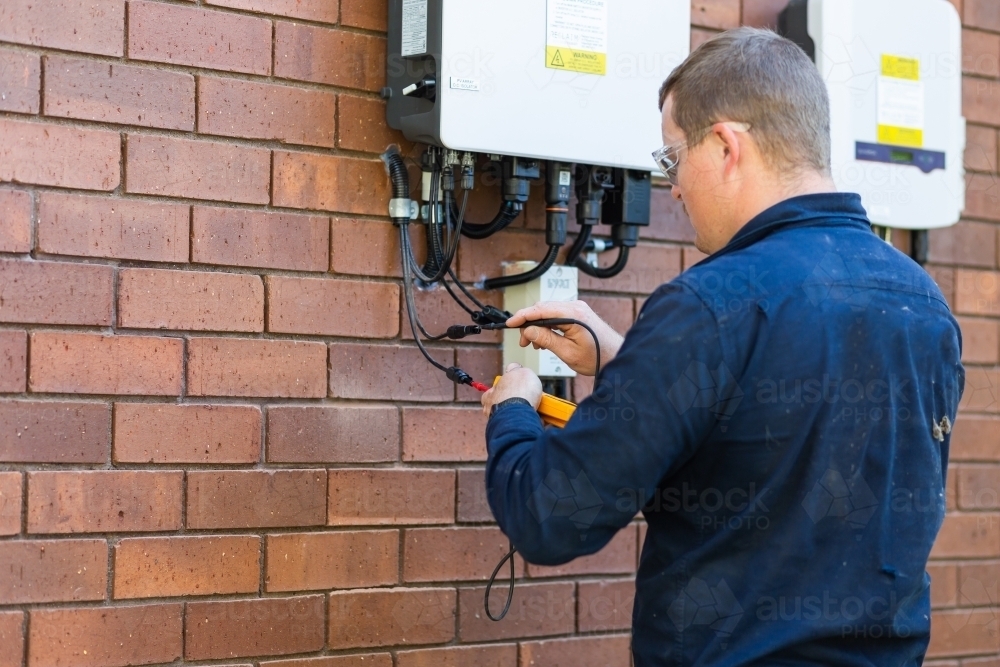 Image of Electrician tradie using multimeter tool to check power in ...