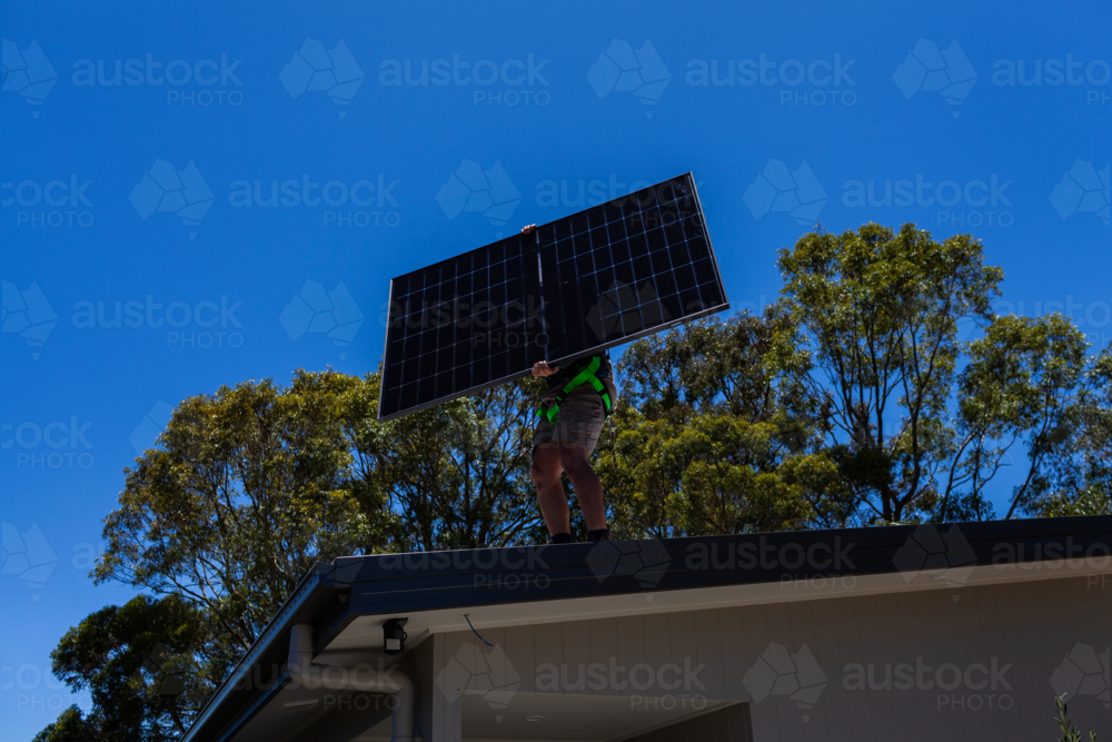 Image of Electrician tradie worker man on roof of suburban house ...