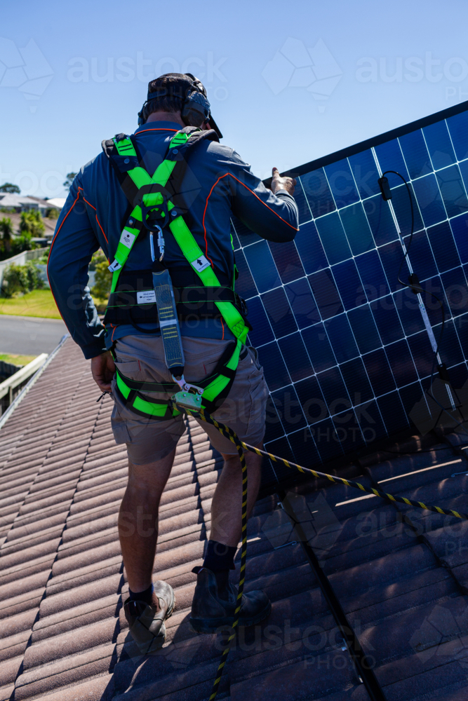 Image of Electrician tradie working on solar panel installation laying ...