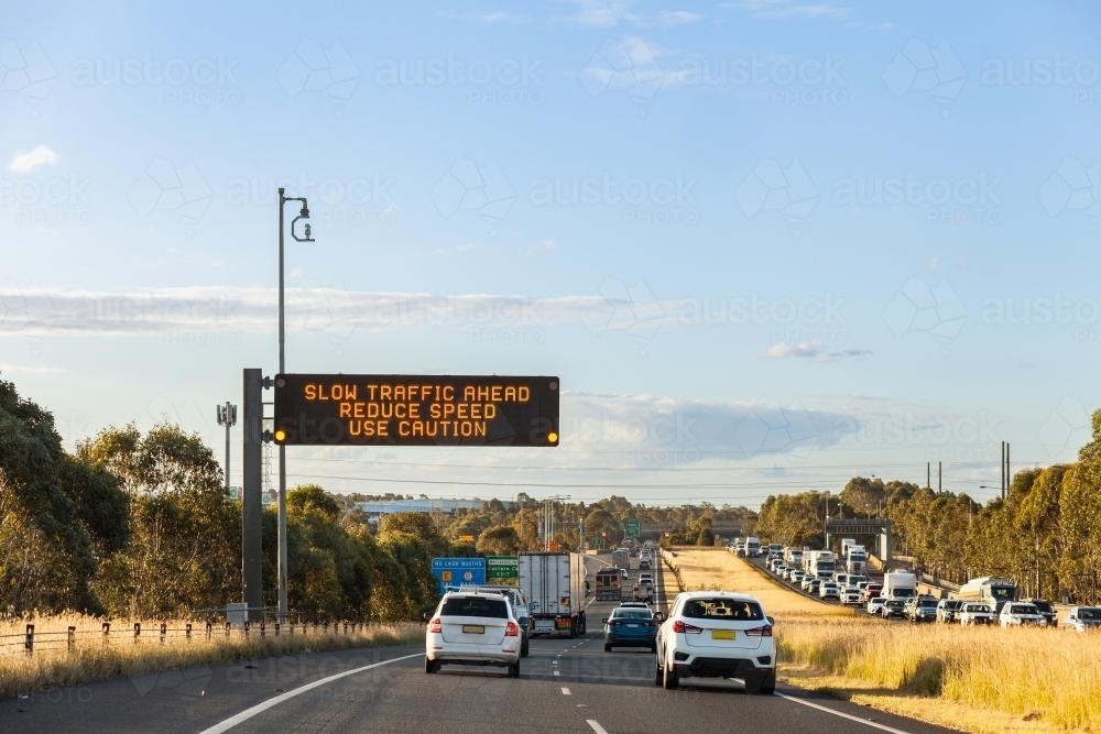 Image of Electronic highway sign warning of slow traffic ahead reduce ...