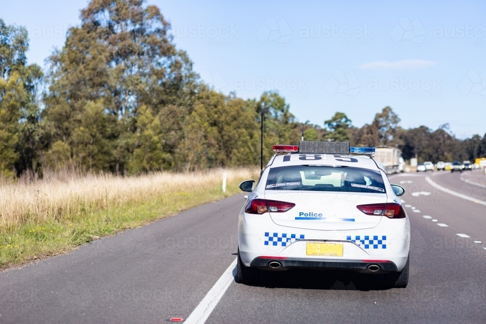 Image of Emergency services traffic patrol police car driving down ...