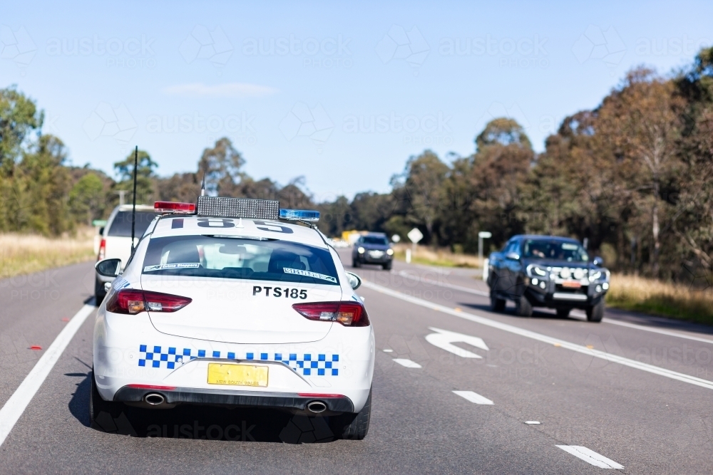 Image of Emergency services traffic patrol police car driving down ...