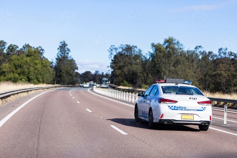Image of Emergency services traffic patrol police car driving down ...