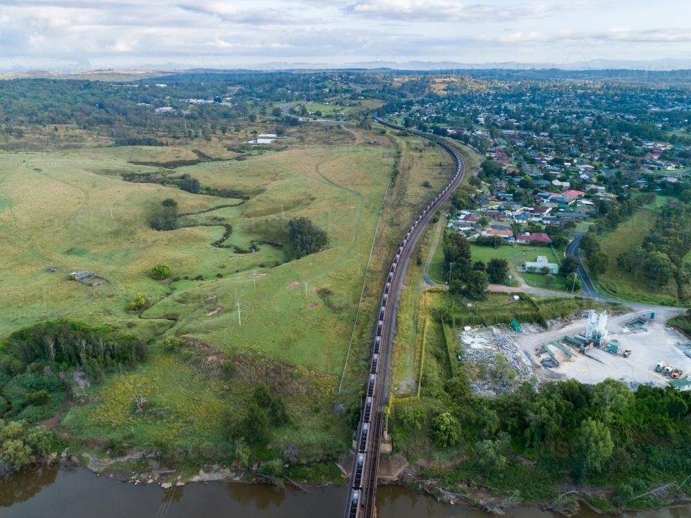 Image of empty coal train travelling on railway beside country town of ...