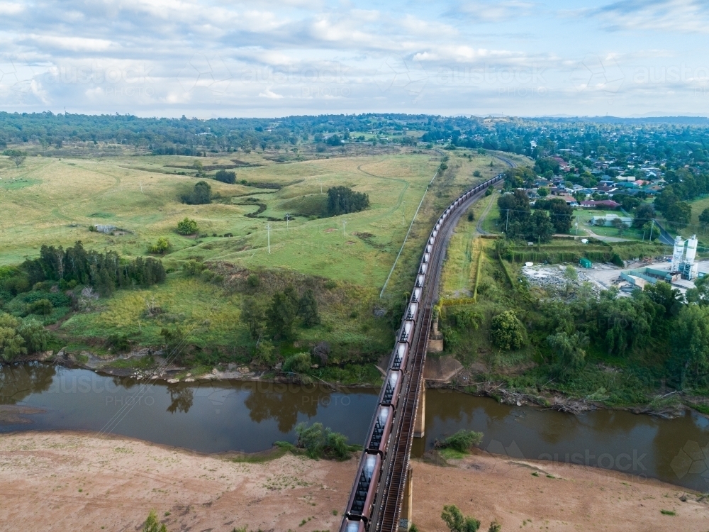 Image of empty coal train travelling on railway beside country town of ...