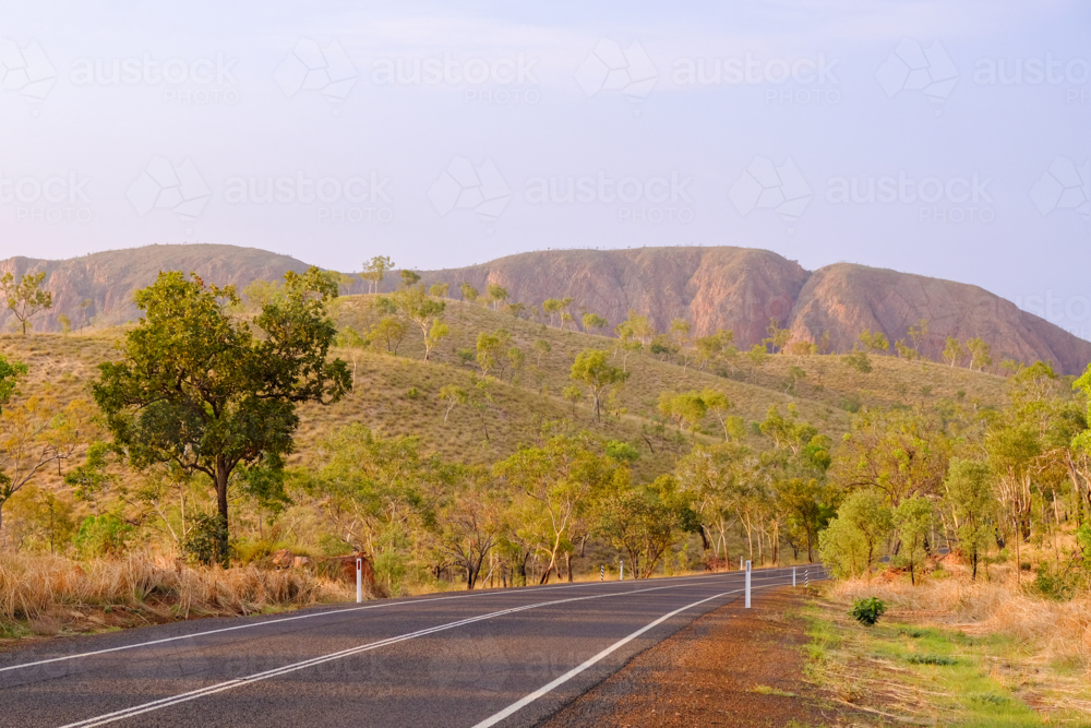 Image of Empty country Road winding into the distant ochre sandstone ...