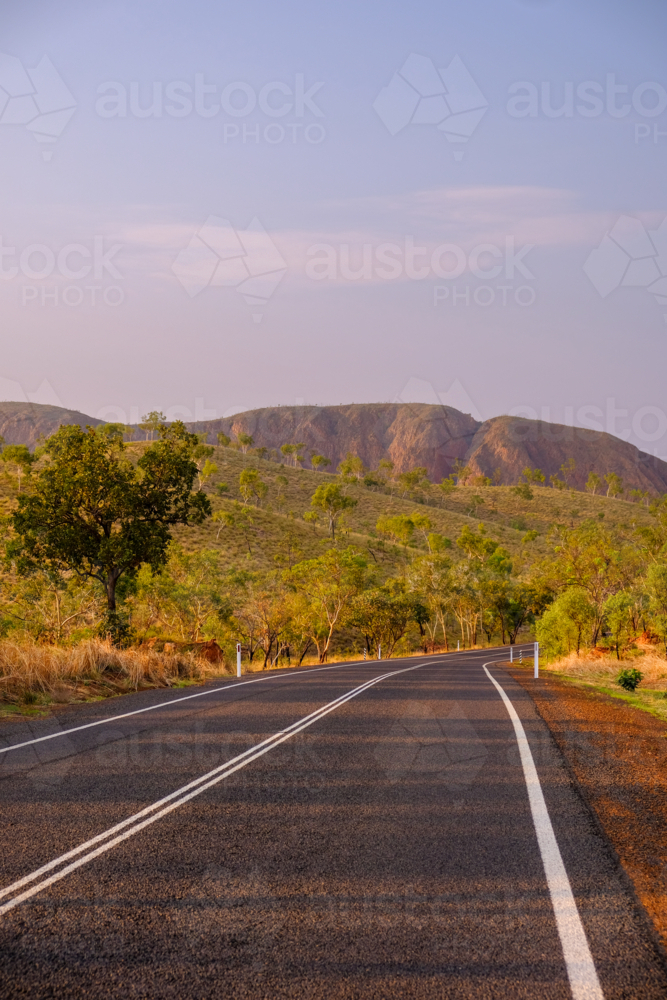 Image of Empty country Road winding into the distant ochre sandstone ...