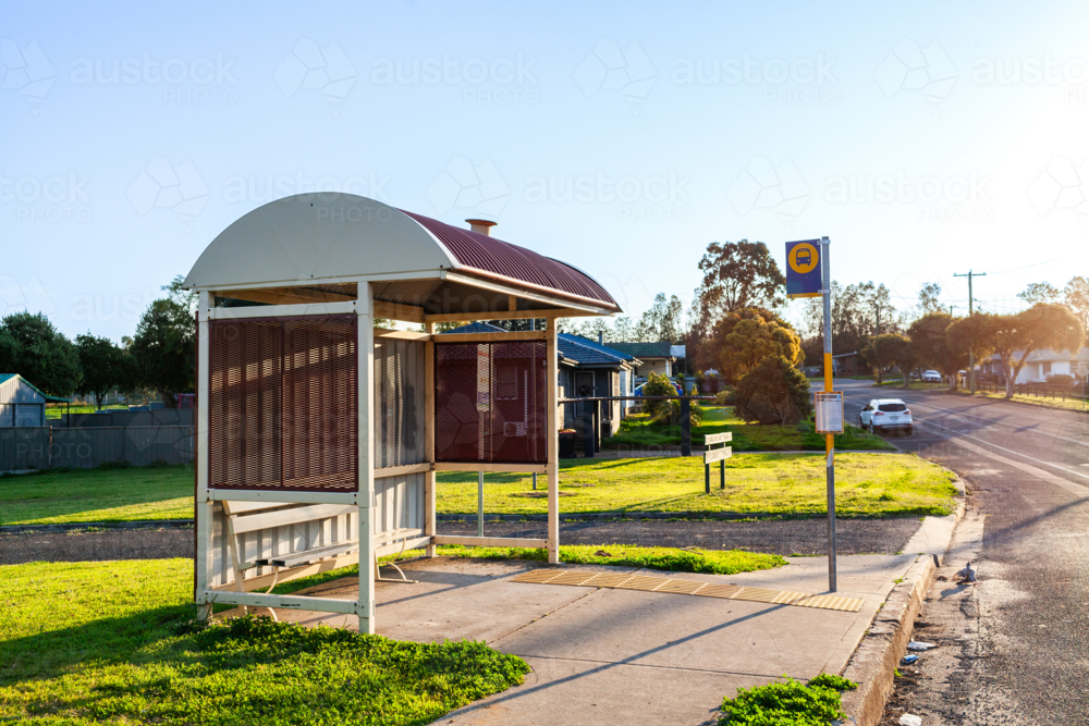 Image of Empty suburban roadside bus stop in golden afternoon light ...