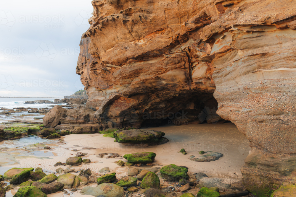 Image of Entrance to large cave inside sandstone cliff face - Austockphoto