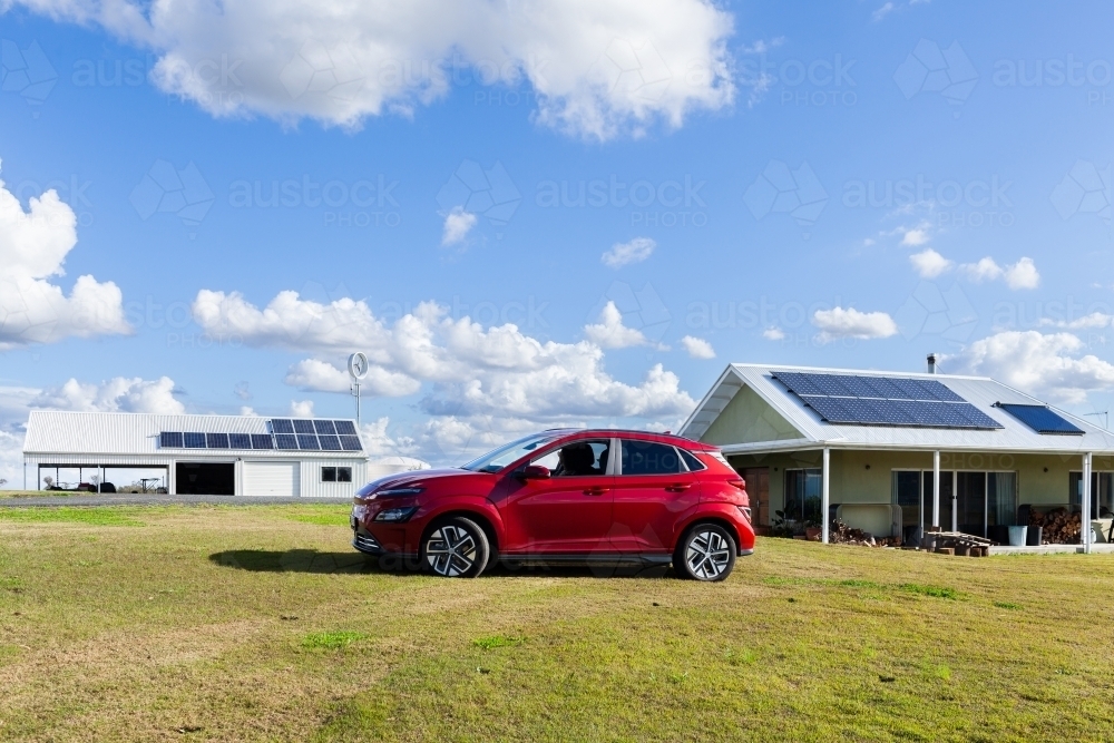 Image of EV car on farm in country, buildings in the background have ...