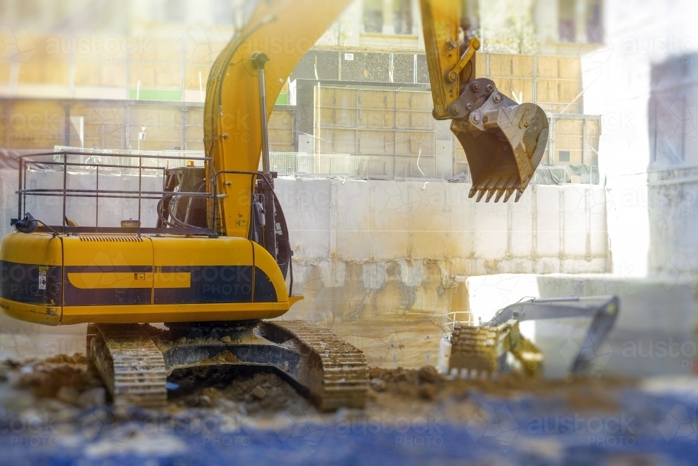 Image of Excavators digging on site in city - Austockphoto