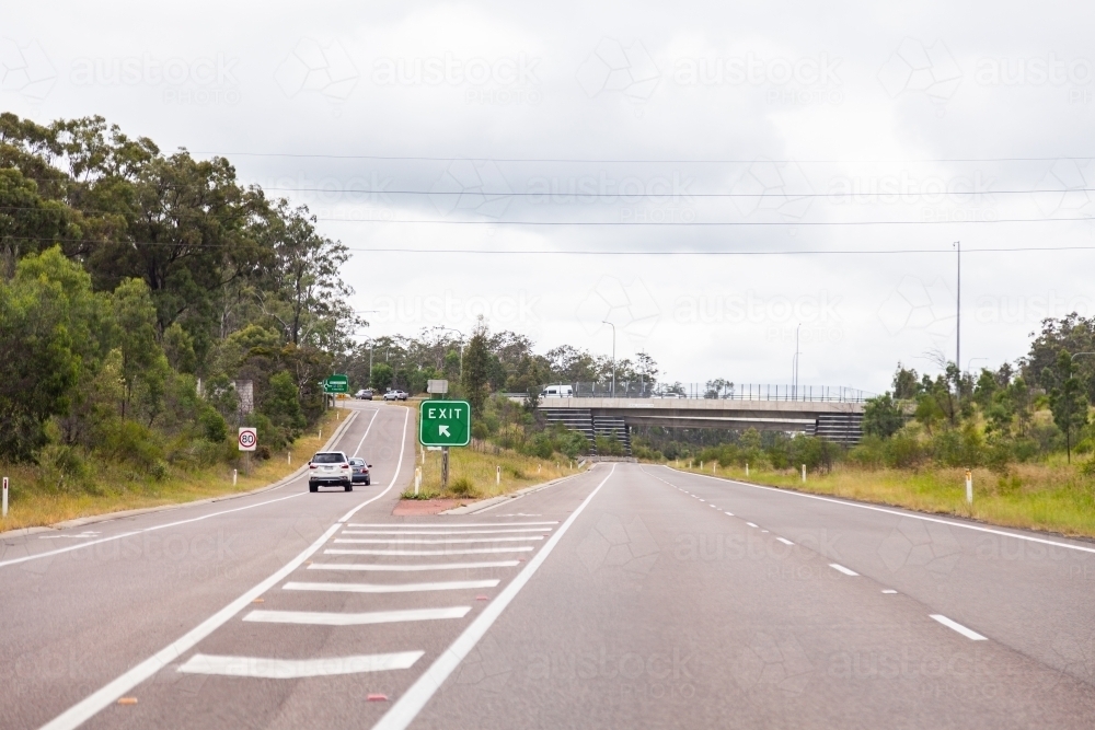 Image of Exit off highway and overpass bridge - Austockphoto