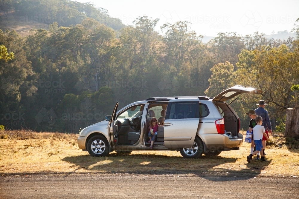 Image of Family getting out of car stopped on the roadside for a break ...