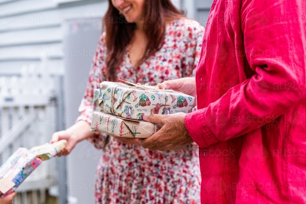 Image of family members exchanging gifts at Christmas family gathering ...