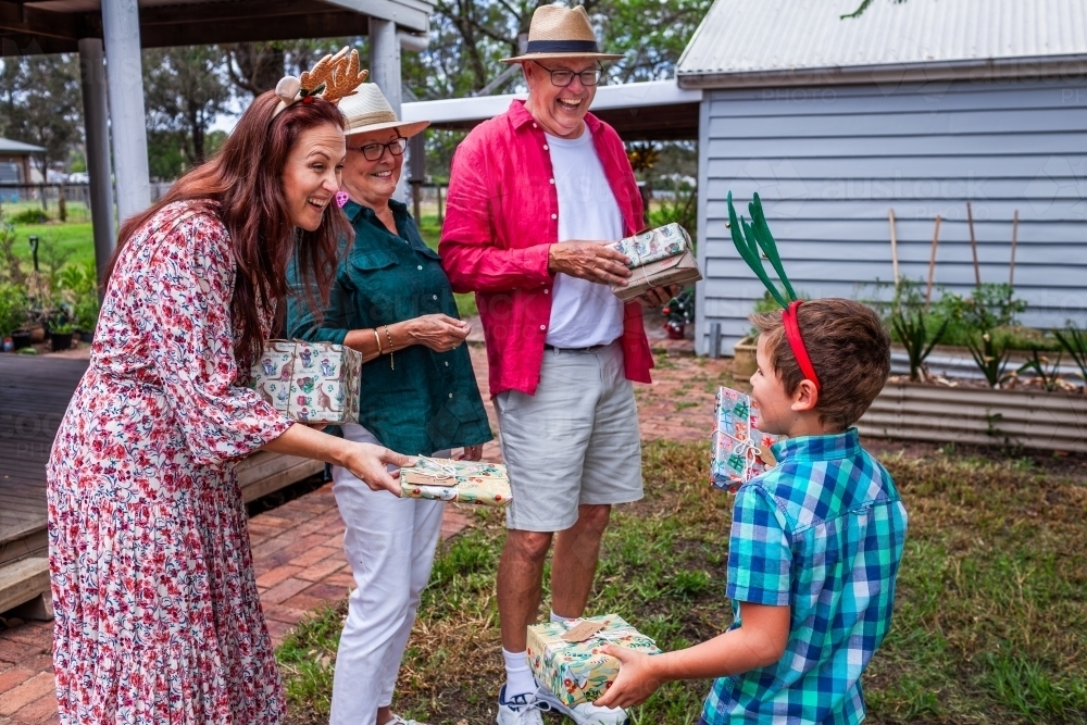 Image of family members exchanging gifts at Christmas family gathering ...