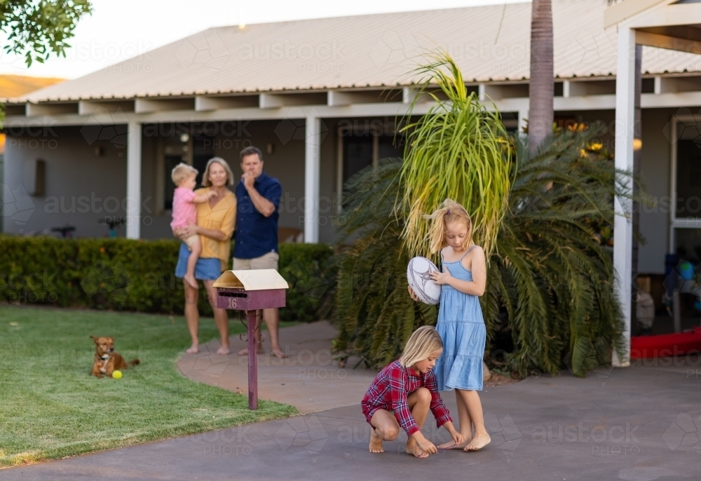 Image of family of five and their dog outside their home - Austockphoto