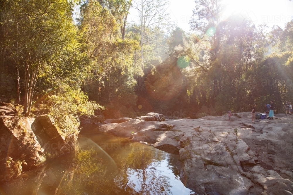 Image of Family on rocks beside pool of water at ladies well with sun ...