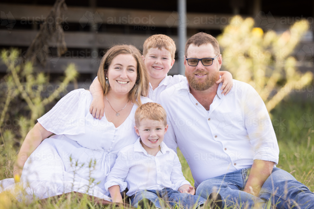 Image of Family portrait sitting together on grass in front of shearing ...