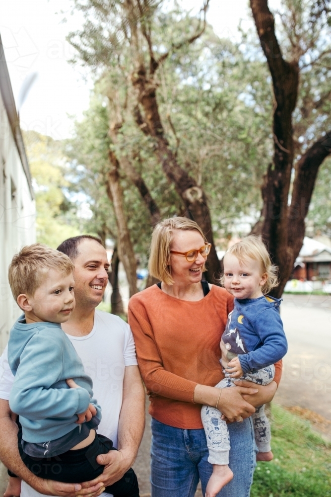 Image of Family walking down footpath with parents carrying children ...