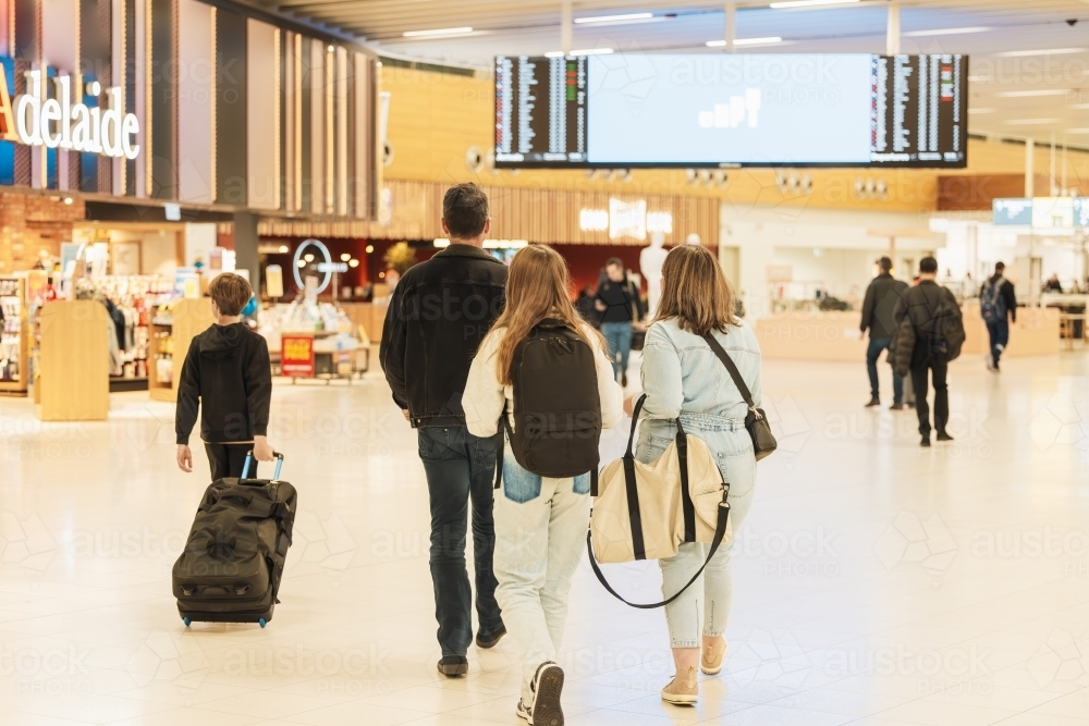 Image of Family walking through airport terminal to catch flight ...